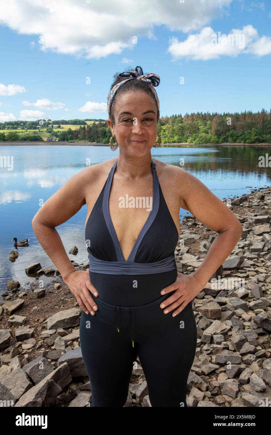 Portrait of woman in swimsuit on rocky lakeshore, Yorkshire, UK Stock ...
