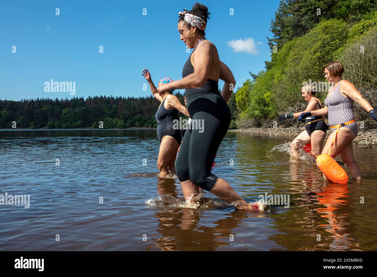Female friends entering lake, Yorkshire, UK Stock Photo - Alamy