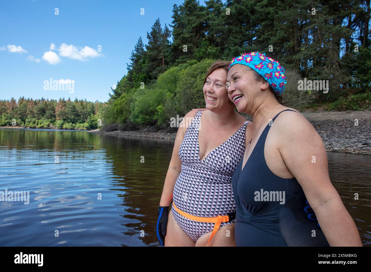Smiling female friends standing in lake, Yorkshire, UK Stock Photo - Alamy