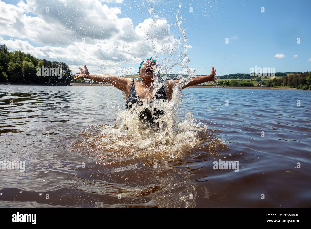 Woman splashing water in lake, Yorkshire, UK Stock Photo - Alamy