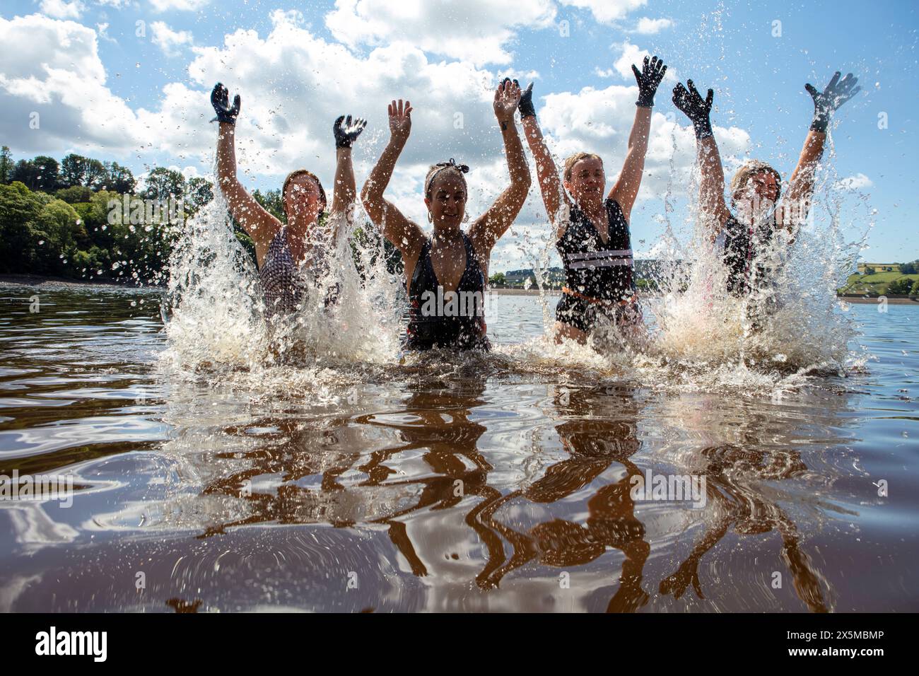 Female friends splashing water in lake, Yorkshire, UK Stock Photo - Alamy