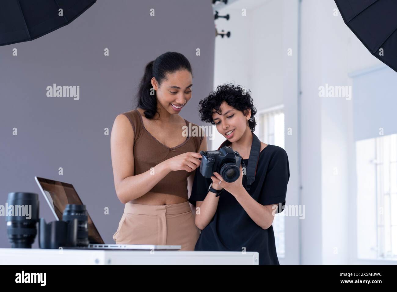Model and photographer looking at camera during photo shoot Stock Photo ...