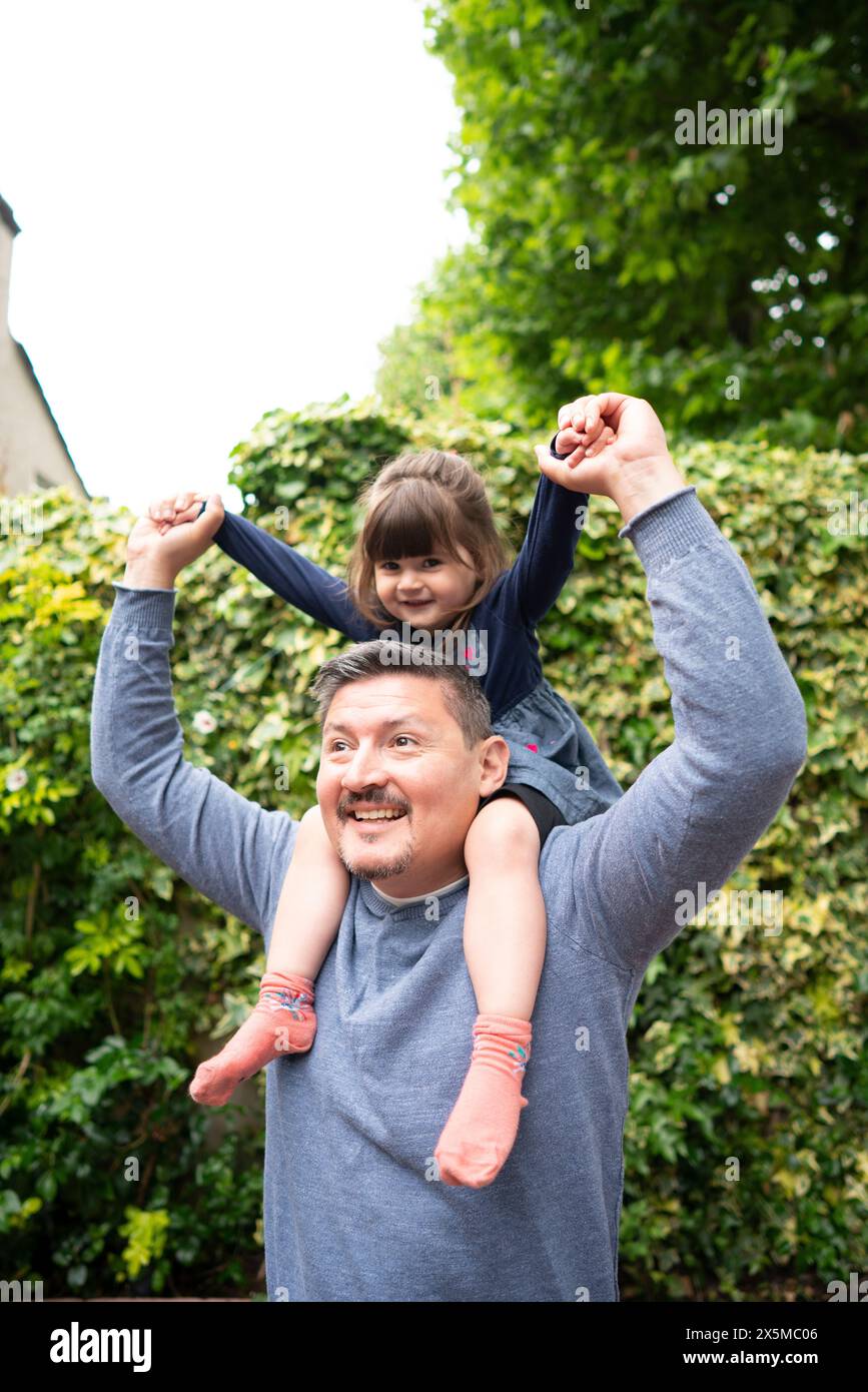Smiling father carrying daughter on shoulders outdoors Stock Photo - Alamy