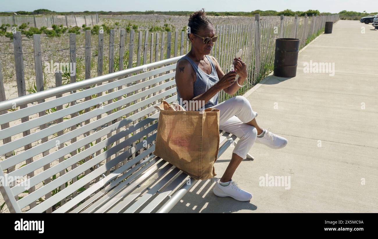Senior woman sitting on bench hi-res stock photography and images - Alamy