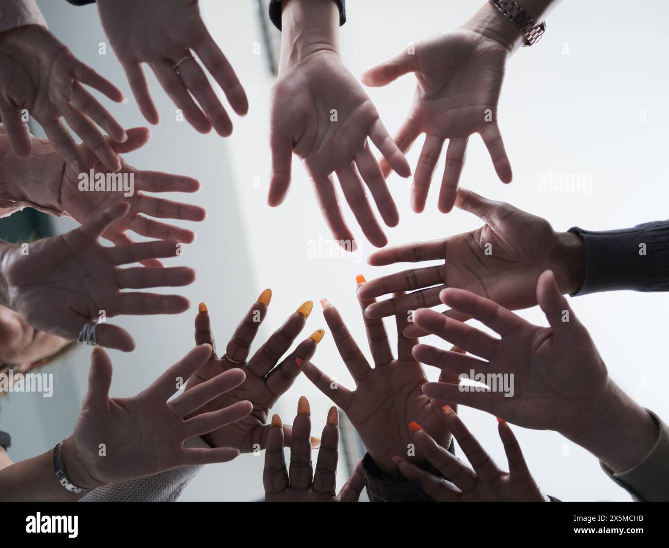 People touching hands together in circle Stock Photo - Alamy