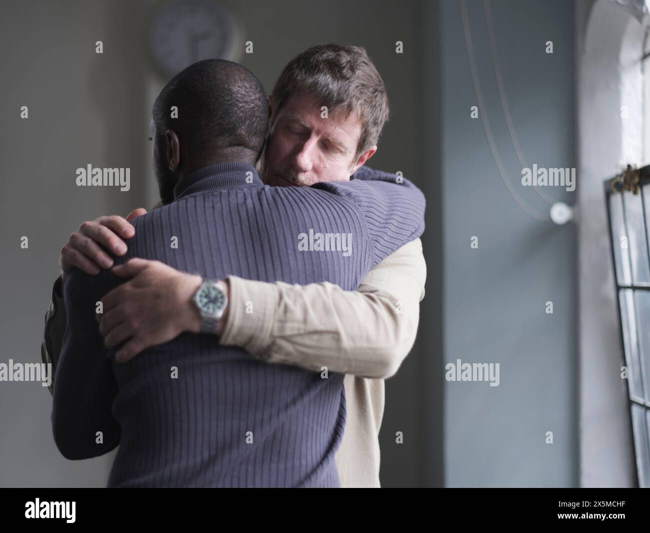 Men hugging in therapy session Stock Photo - Alamy