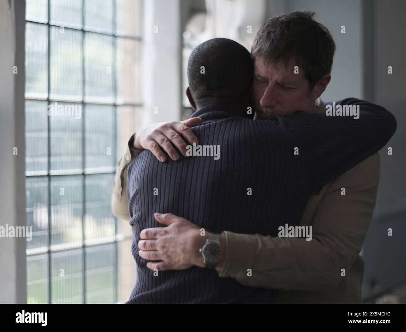 Men hugging in therapy session Stock Photo - Alamy