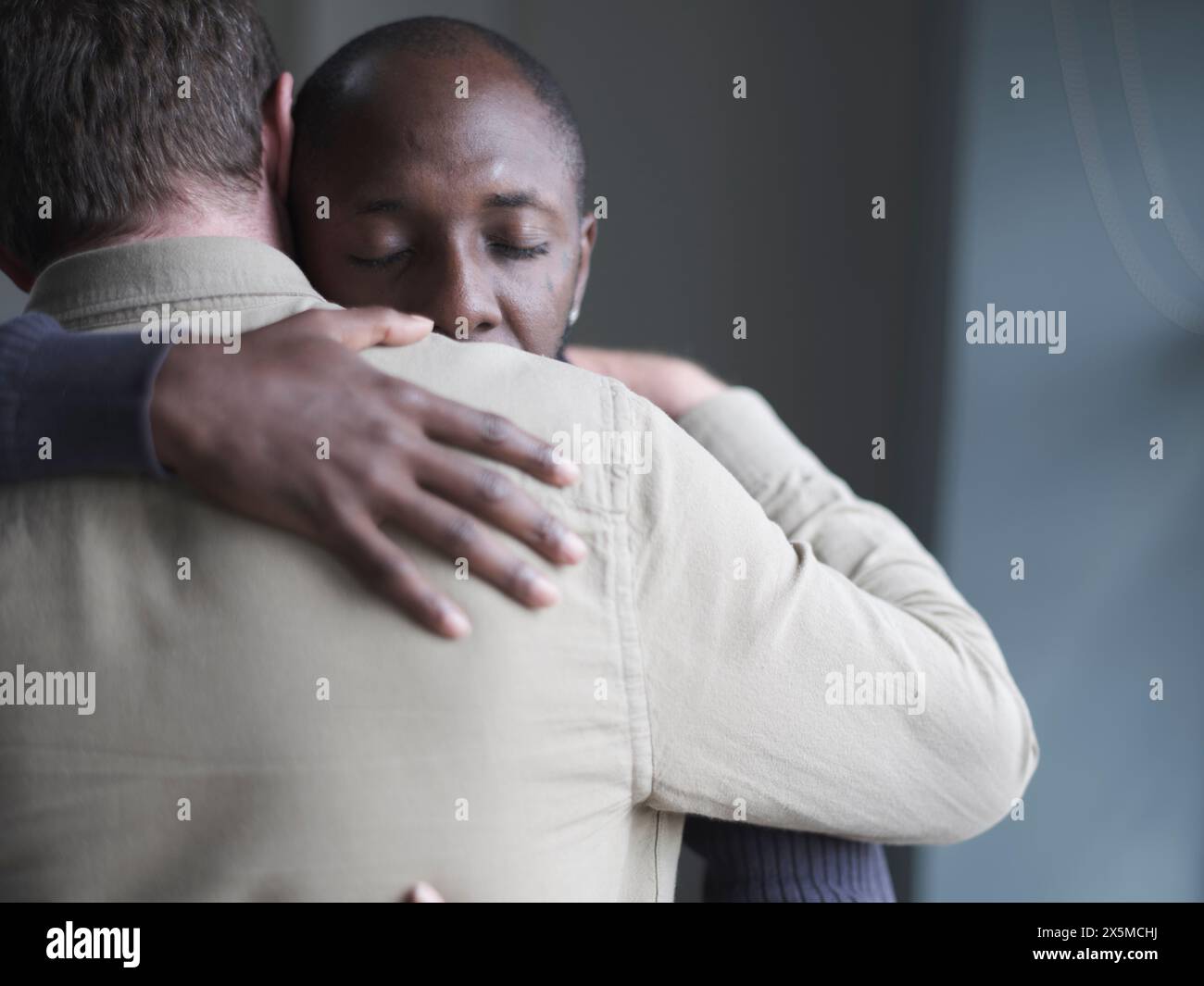 Men hugging in therapy session Stock Photo - Alamy
