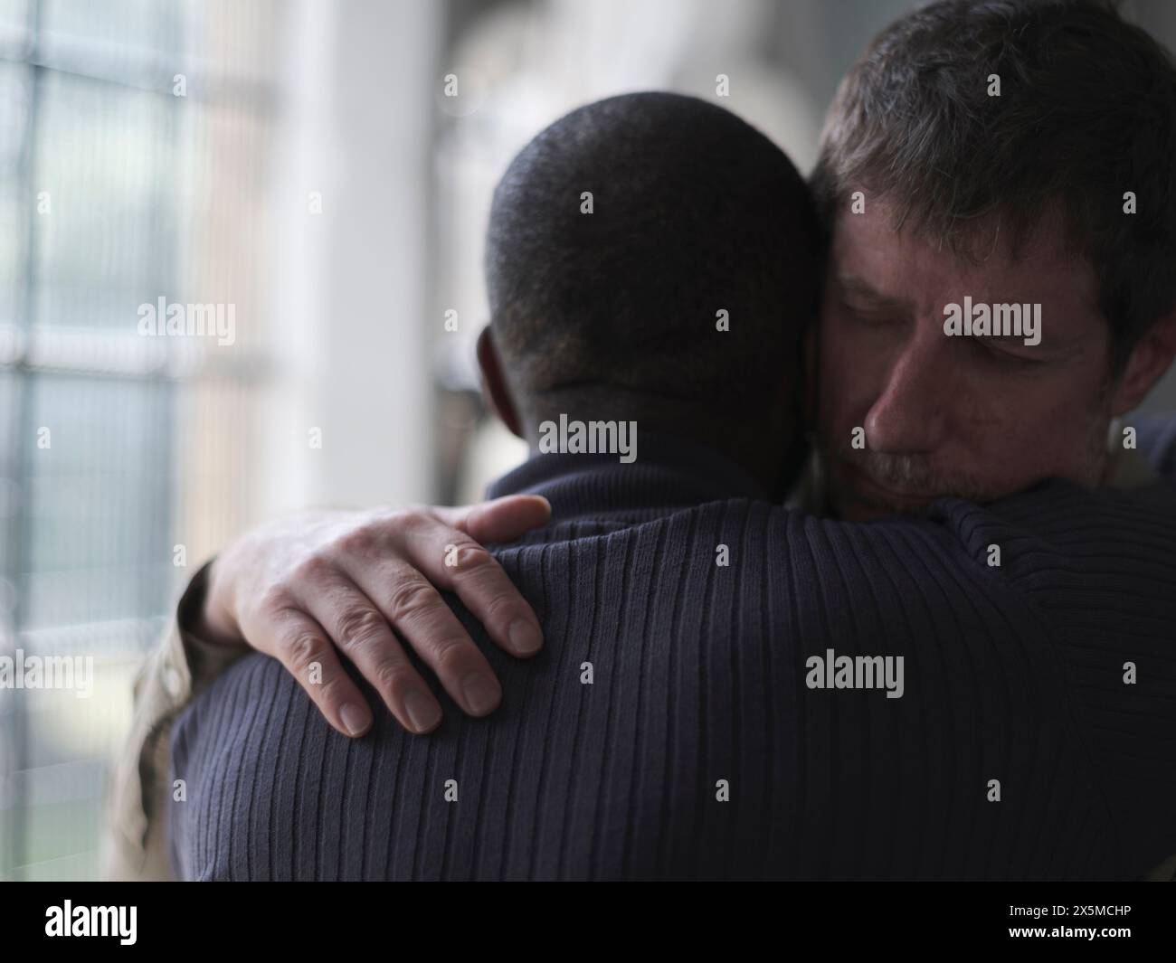 Men hugging in therapy session Stock Photo - Alamy