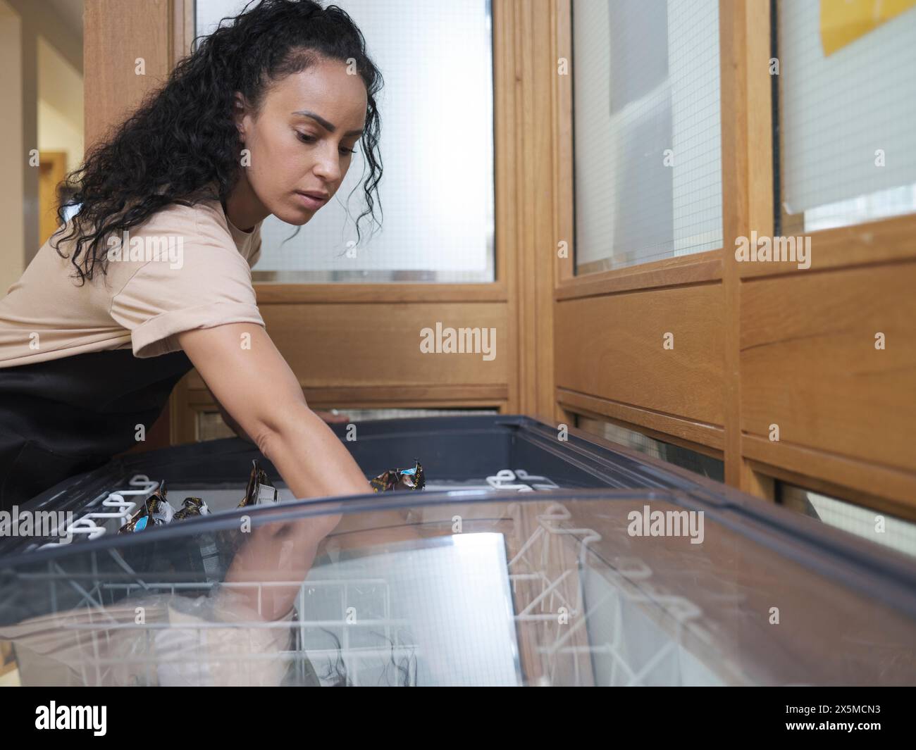 Female volunteer working in food community center Stock Photo - Alamy