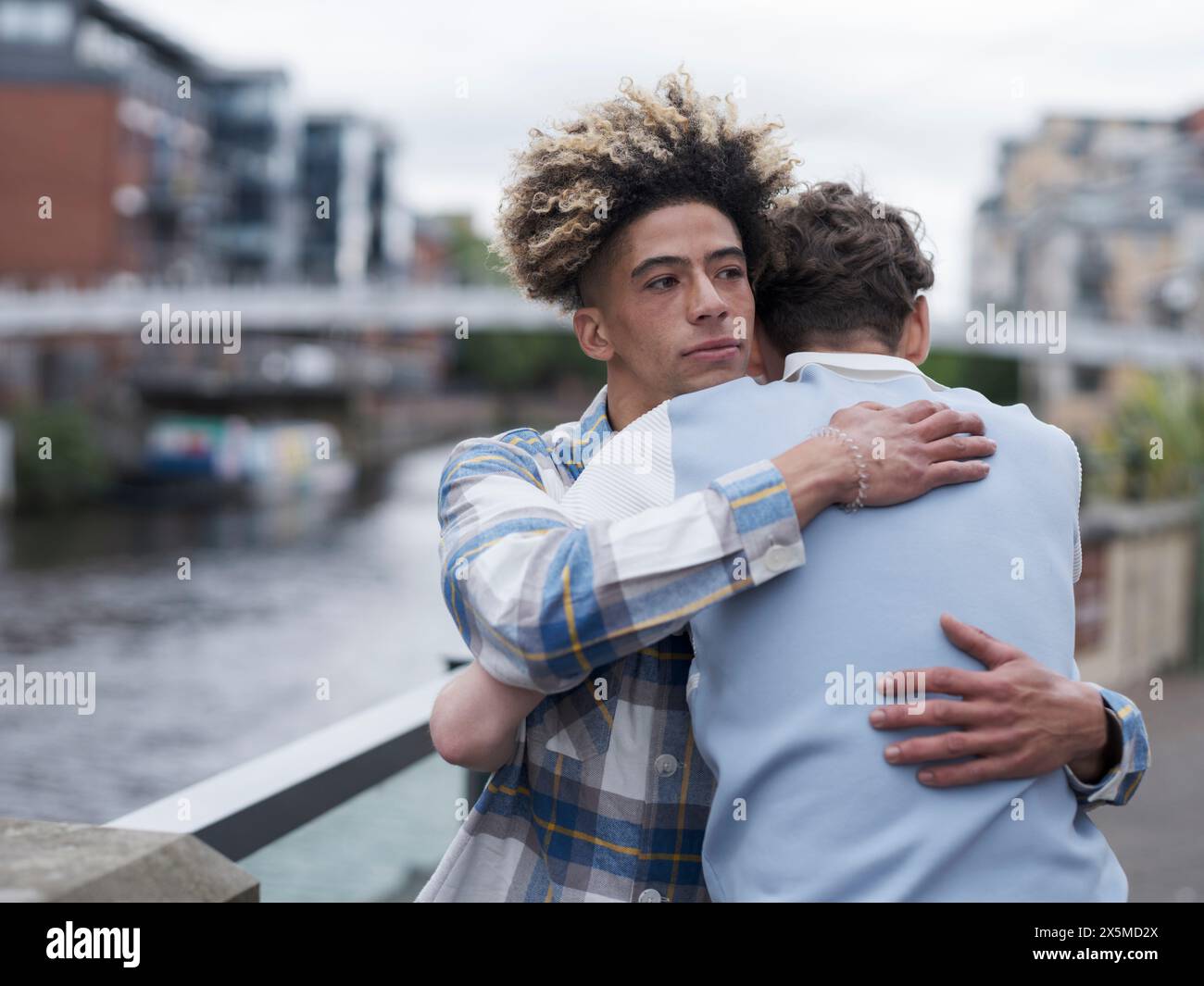 Young men hugging Stock Photo - Alamy