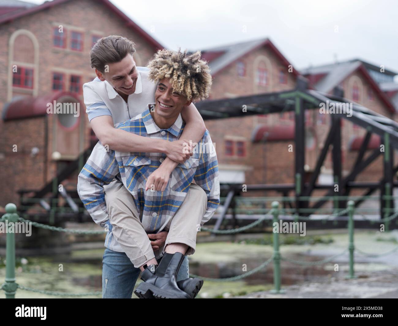 Man giving boyfriend piggyback ride Stock Photo - Alamy