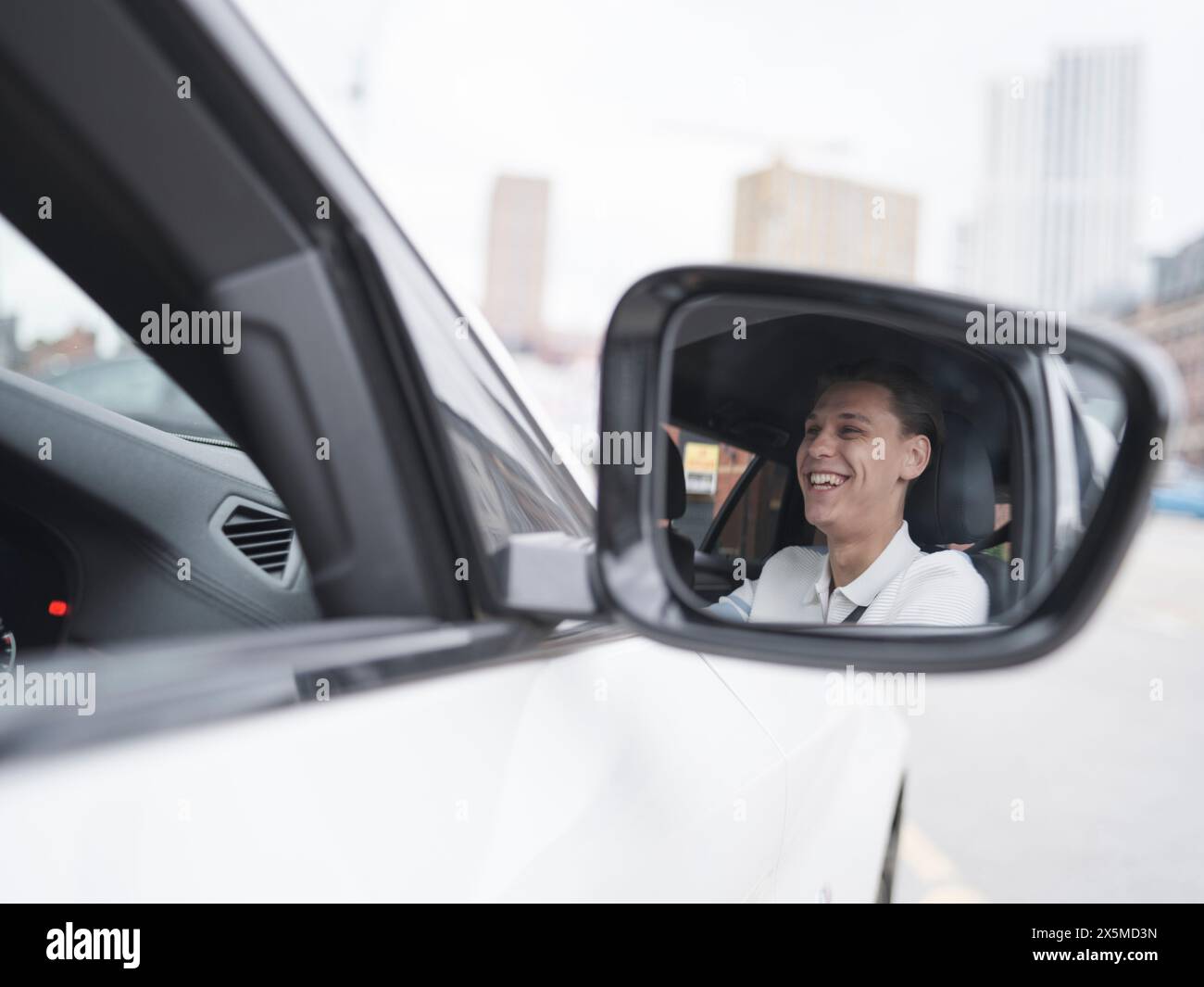 Reflection of smiling man in side mirror Stock Photo - Alamy