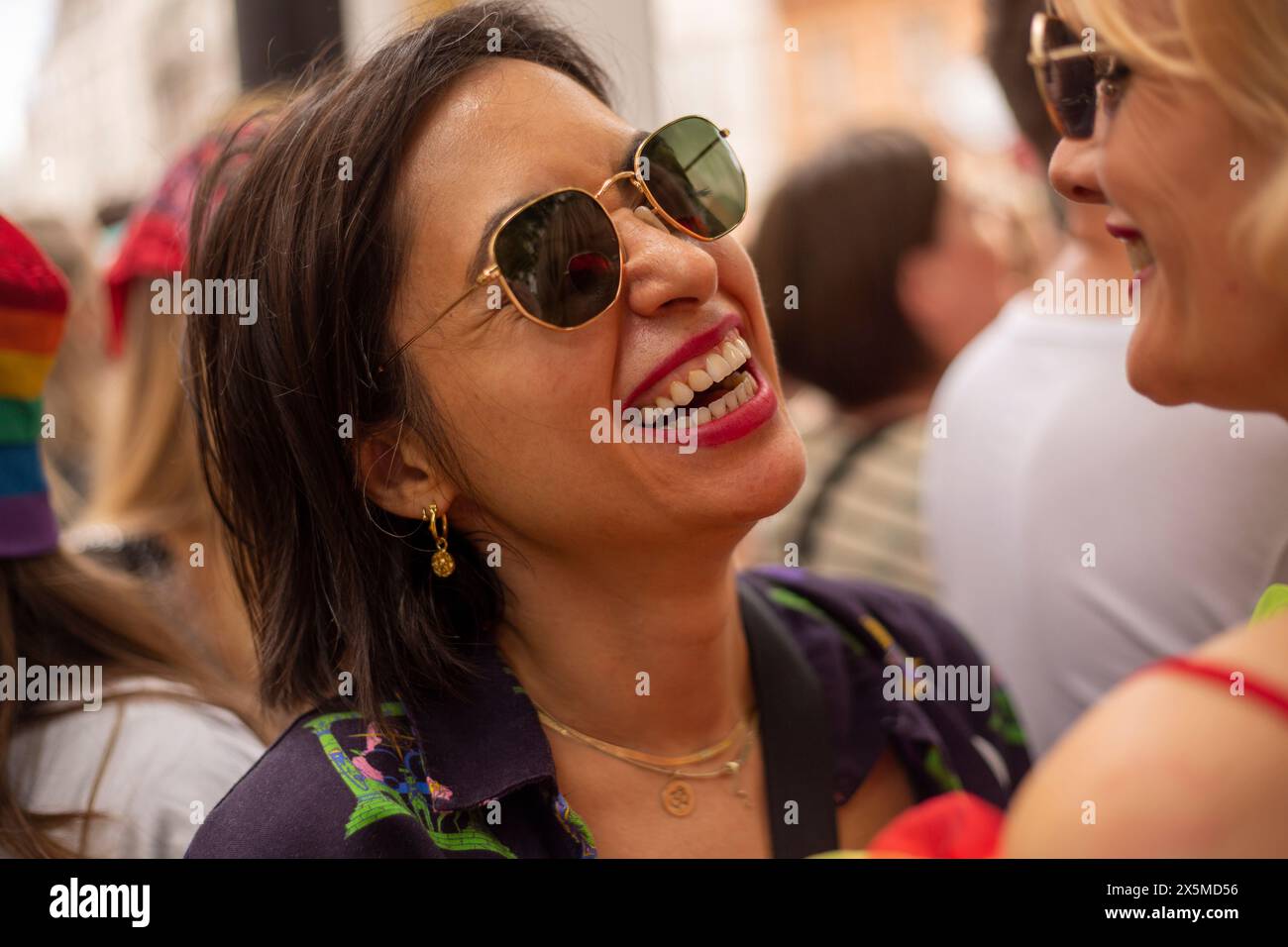 Two laughing women in crowd Stock Photo - Alamy