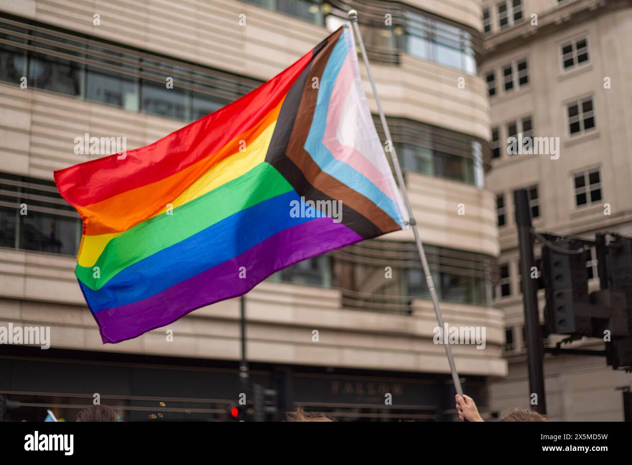 LGBT parade, person holding progress pride flag Stock Photo - Alamy
