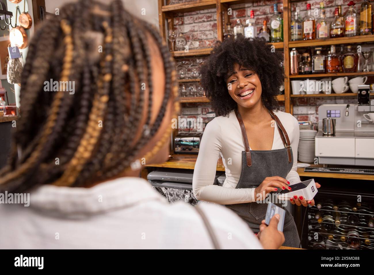 UK, London, Smiling cafe owner and customer with credit card Stock ...