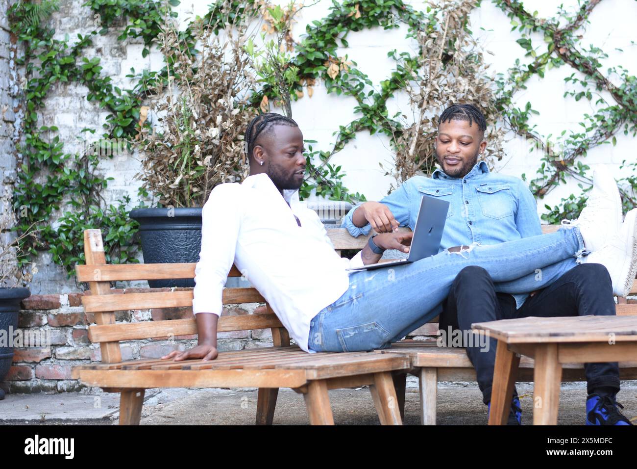 USA, Louisiana, Smiling gay couple with laptop on backyard Stock Photo - Alamy
