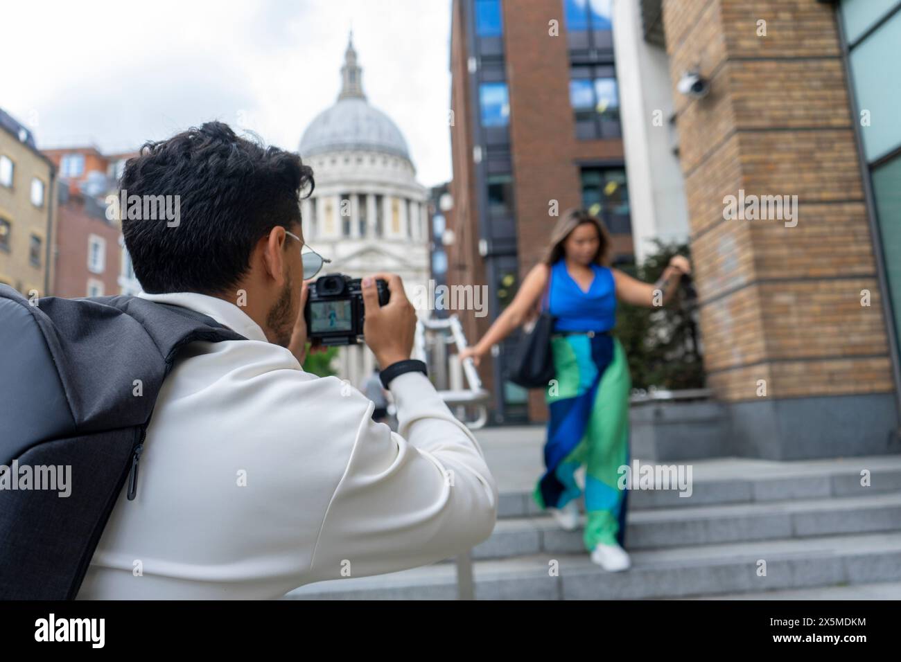 United Kingdom, London, Man taking pictures of woman in street Stock ...