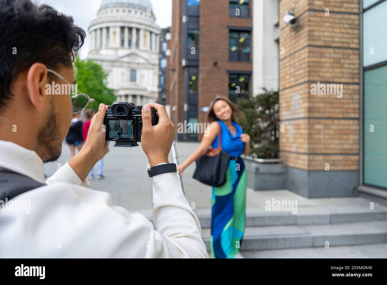 United Kingdom, London, Man taking pictures of woman in street Stock ...