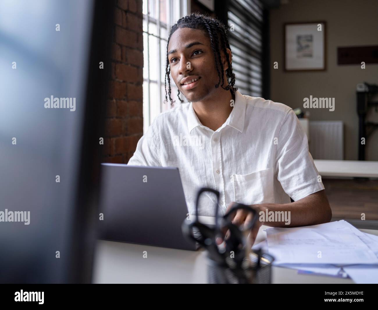 Teenage (16-17) boy using laptop in office Stock Photo - Alamy