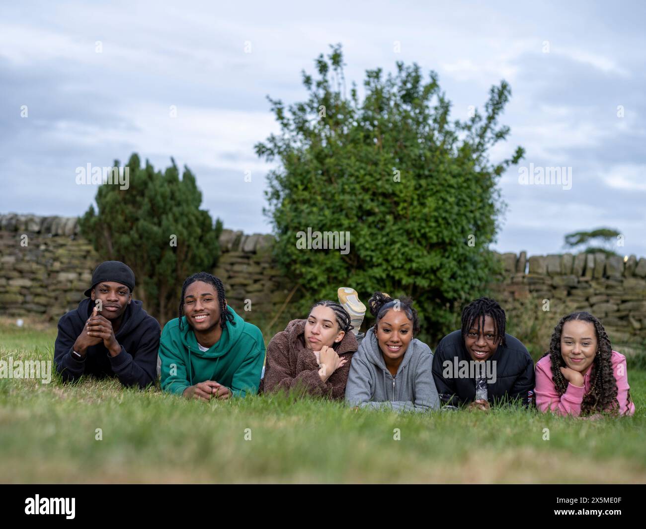 Group of teenage (16-17) friends lying on grass Stock Photo - Alamy