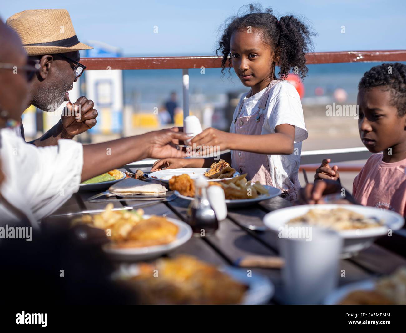 Family with children (6-7, 8-9) eating in outdoor restaurant Stock ...
