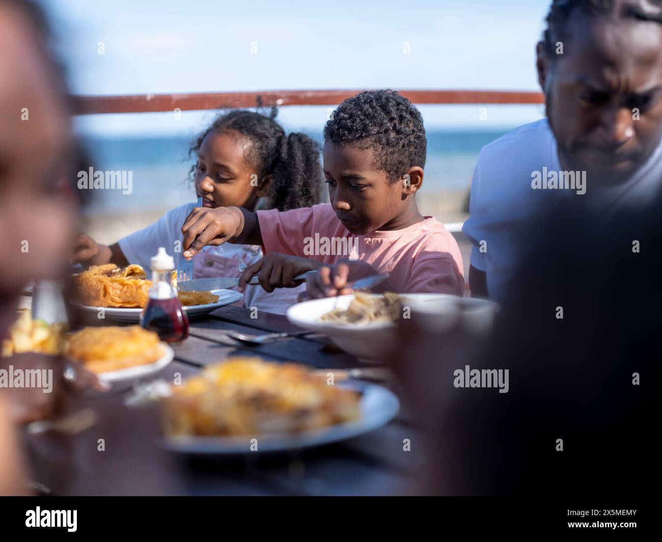 Family with children (6-7, 8-9) eating in outdoor restaurant Stock ...