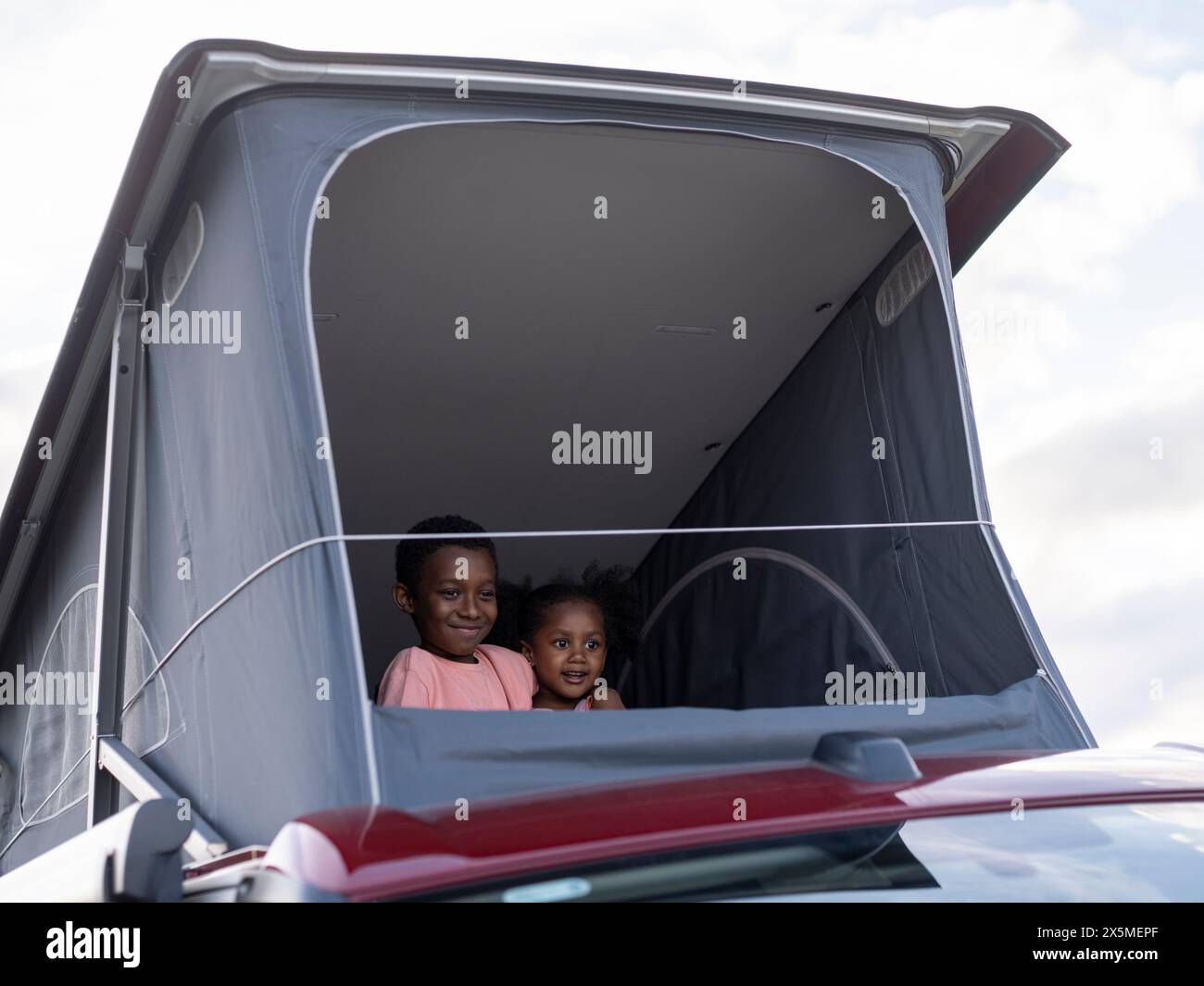 Siblings (2-3, 8-9) in camper van rooftop tent Stock Photo - Alamy