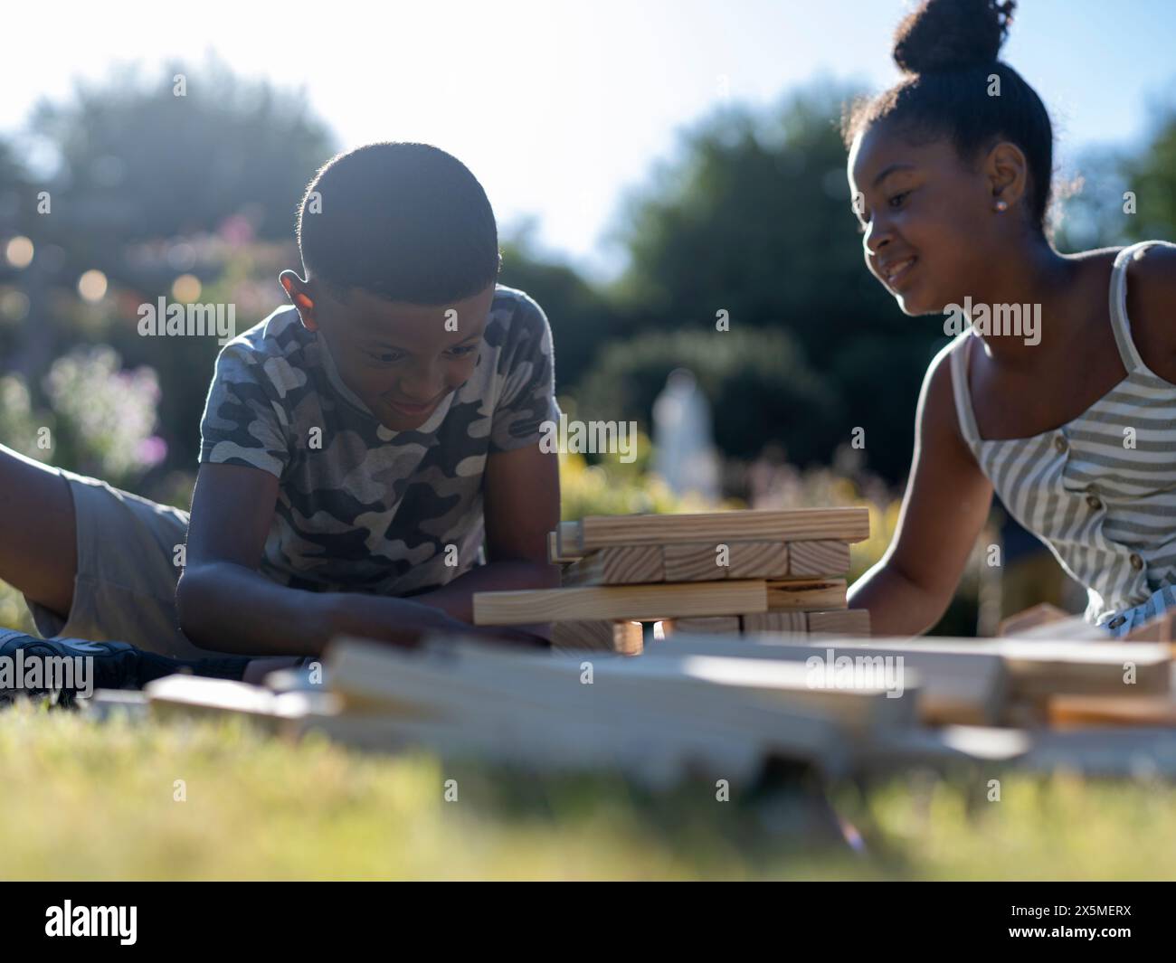 Siblings (8-9, 10-11) playing block removal game Stock Photo - Alamy