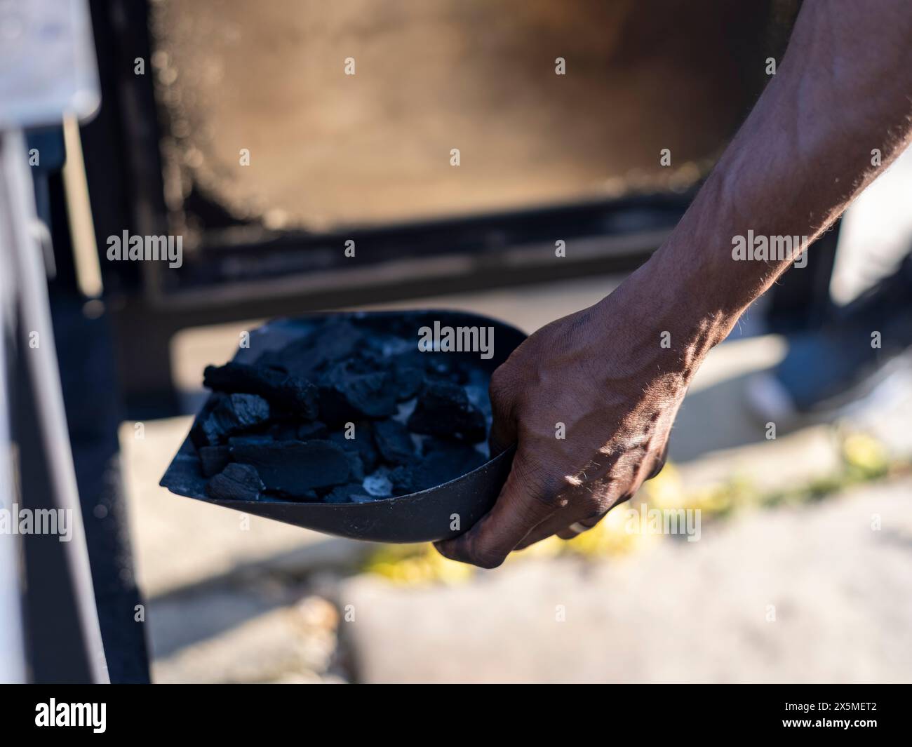 Man starting barbecue grill Stock Photo - Alamy