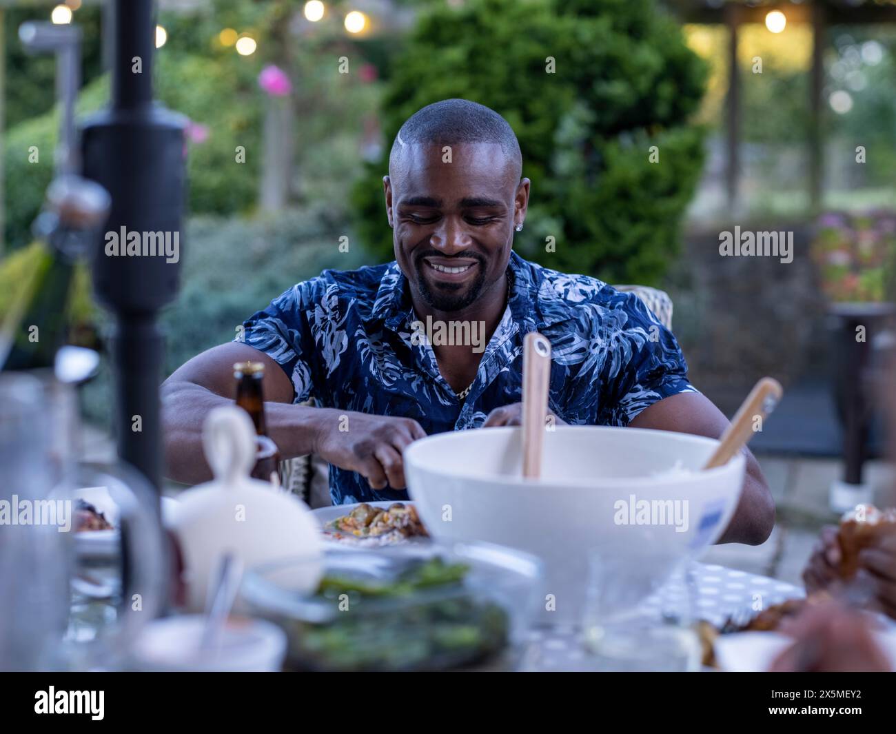 Smiling man eating dinner outdoors Stock Photo - Alamy