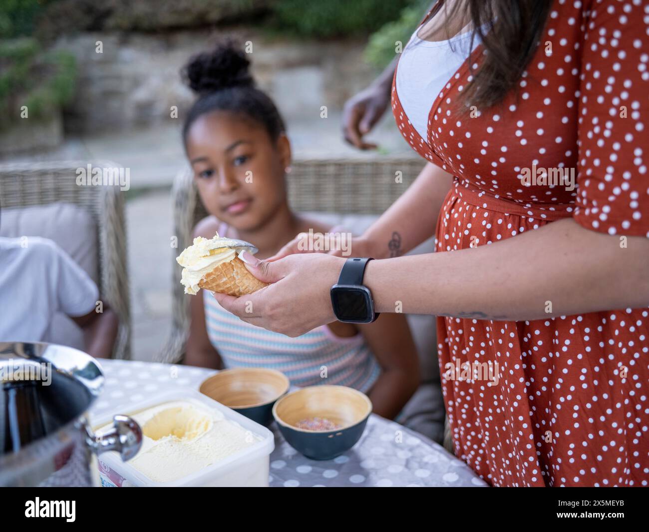 Mother preparing ice cream for daughter (8-9 Stock Photo - Alamy