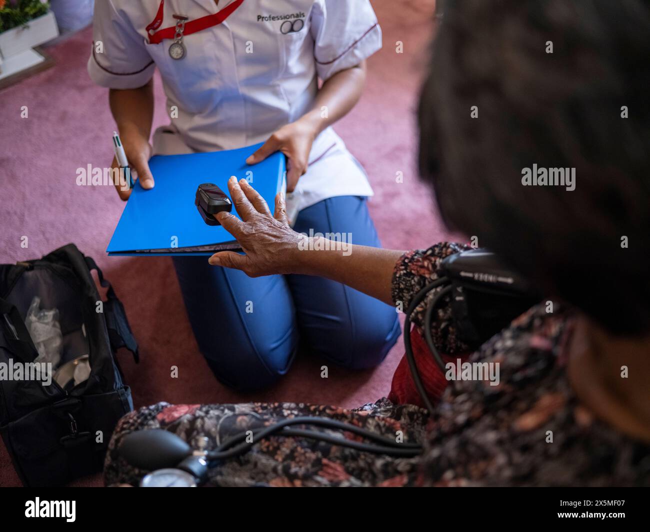Nurse taking care of elderly woman, measuring oxygen saturation Stock ...