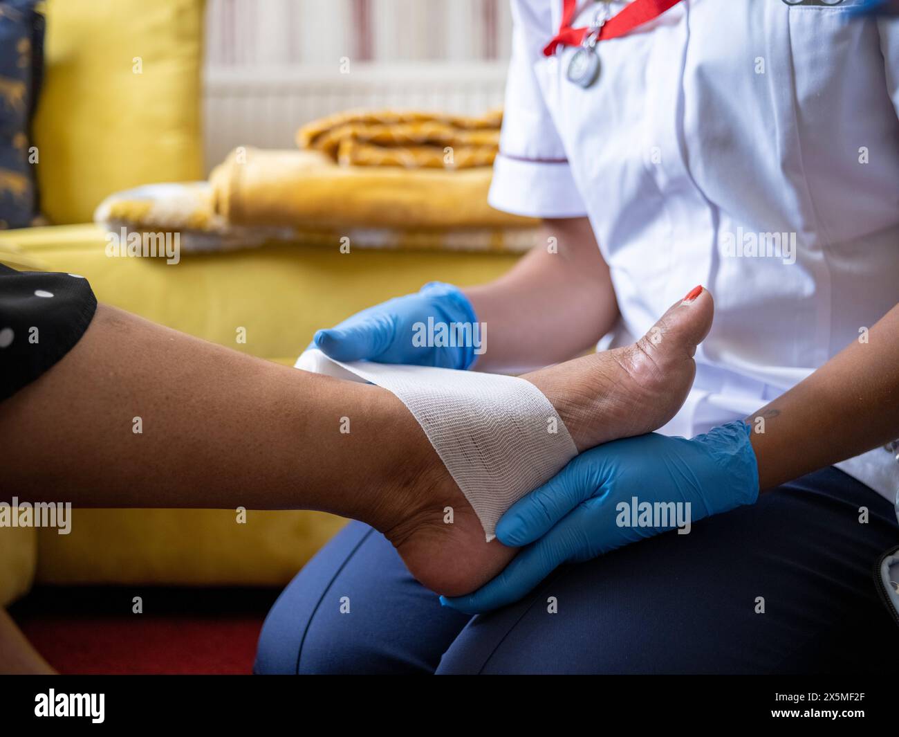 Nurse taking care of patients foot Stock Photo - Alamy