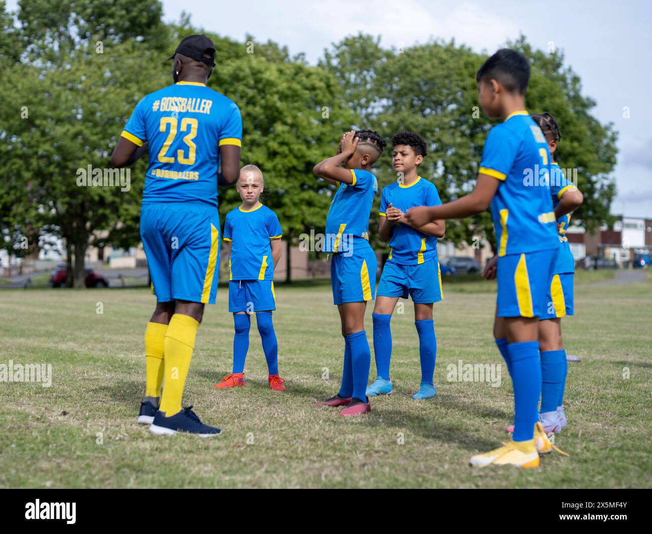 Coach meeting with kids (8-9) on soccer field Stock Photo - Alamy