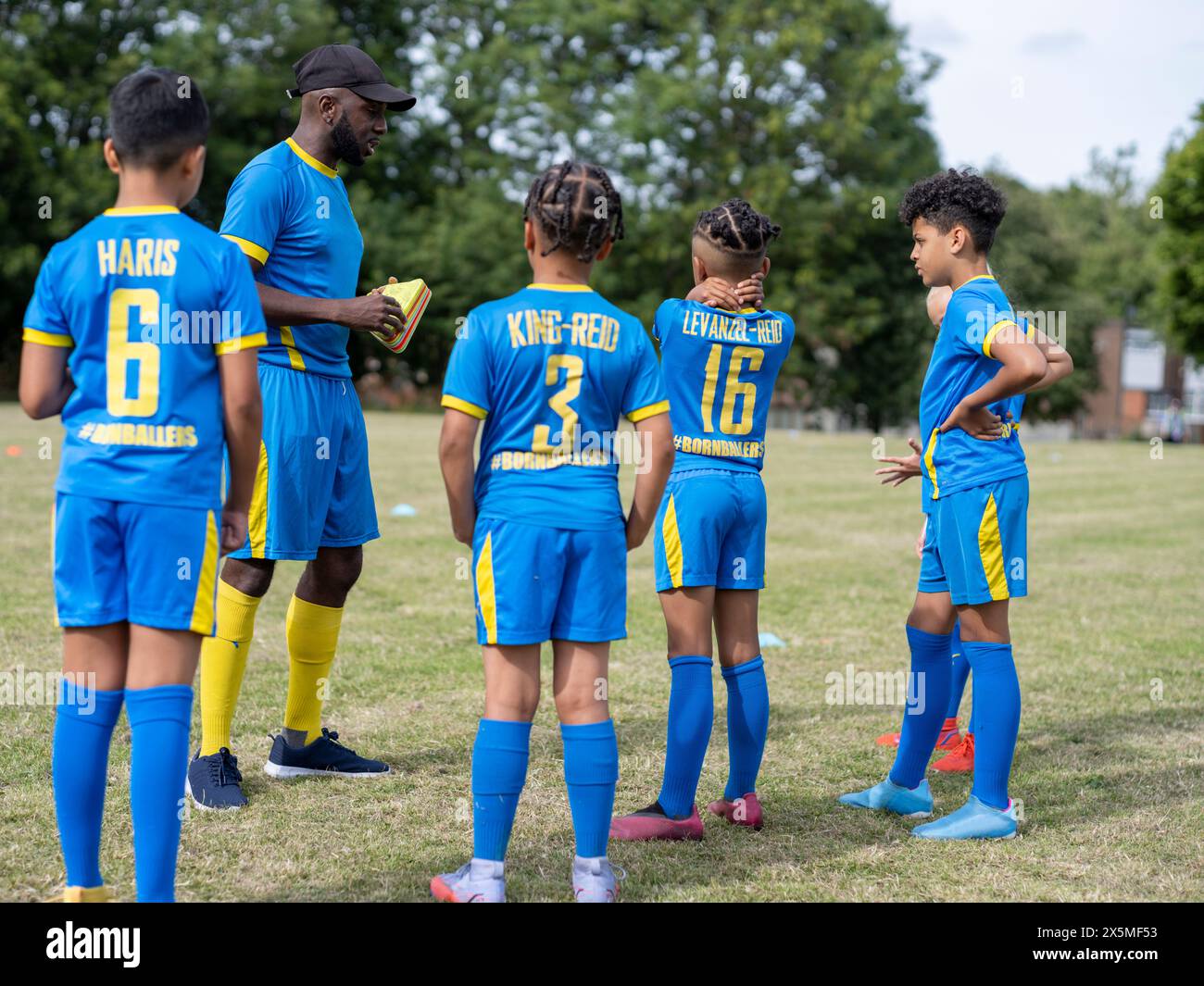 Coach meeting with kids (8-9) on soccer field Stock Photo - Alamy