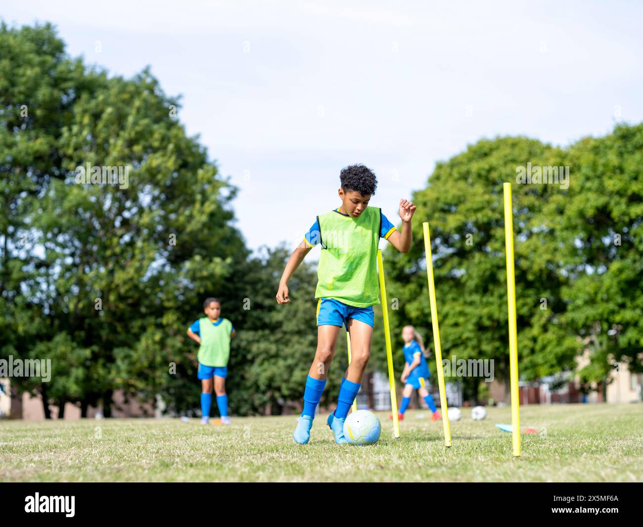 Children (8-9) dressed in uniforms practicing on soccer field Stock ...