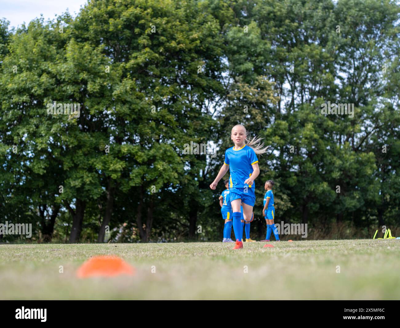 Girl (8-9) dressed in uniform practicing on soccer field Stock Photo ...