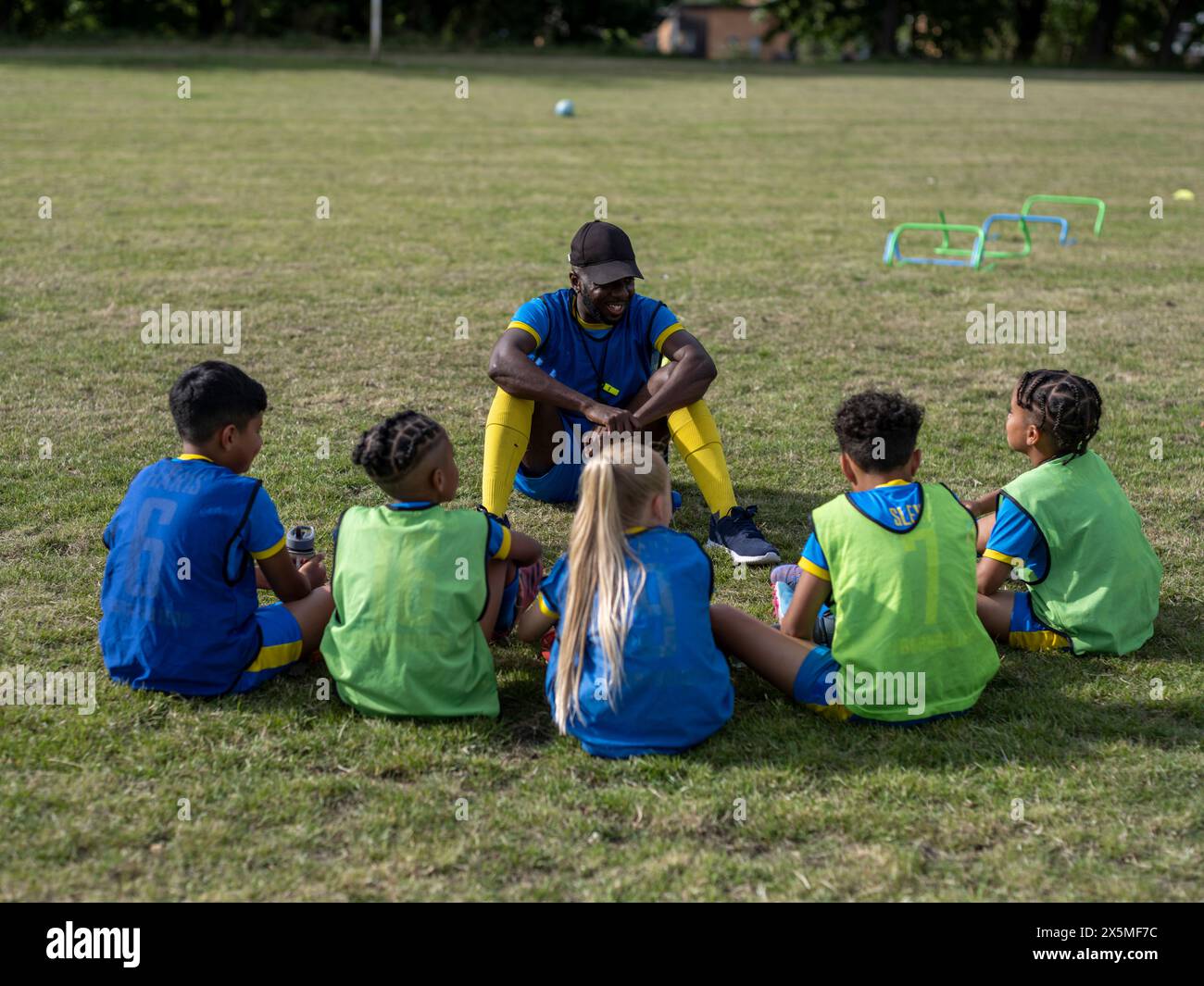 Coach giving instructions to kids (8-9) on soccer field Stock Photo - Alamy