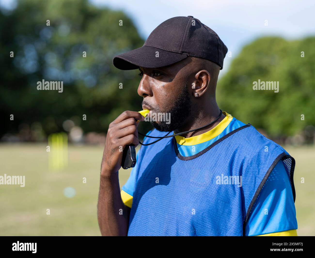 Coach using whistle on soccer field Stock Photo - Alamy
