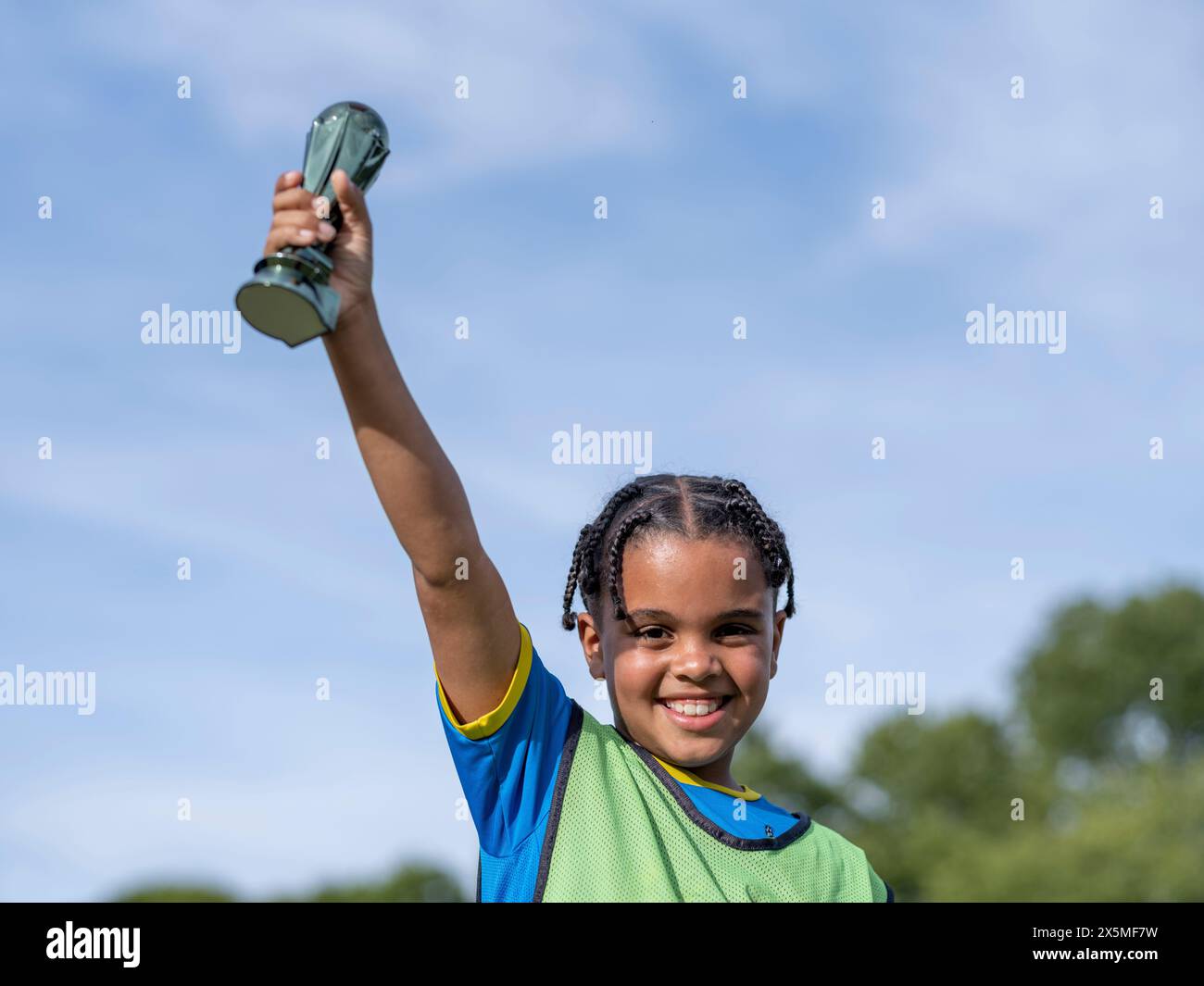 Boy (8-9) dressed in soccer uniform holding prize Stock Photo - Alamy