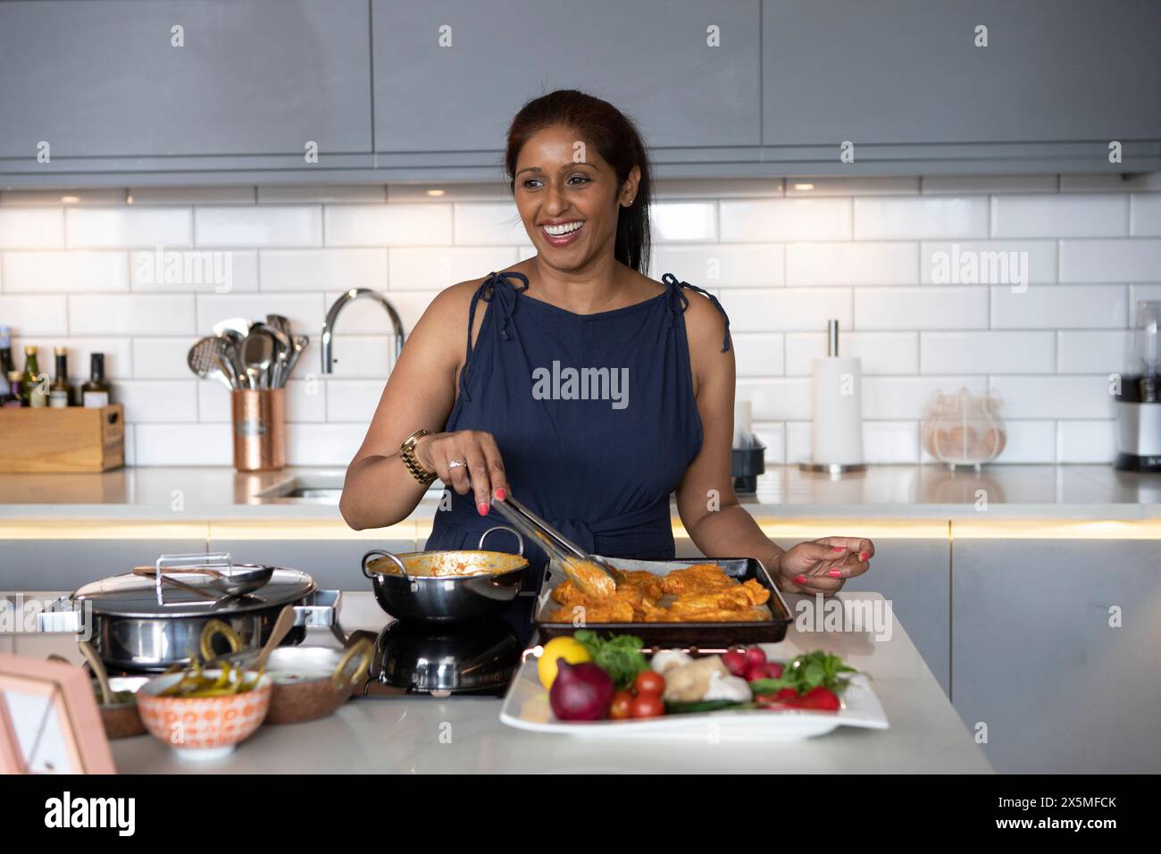 UK, London, Smiling woman cooking in kitchen Stock Photo - Alamy