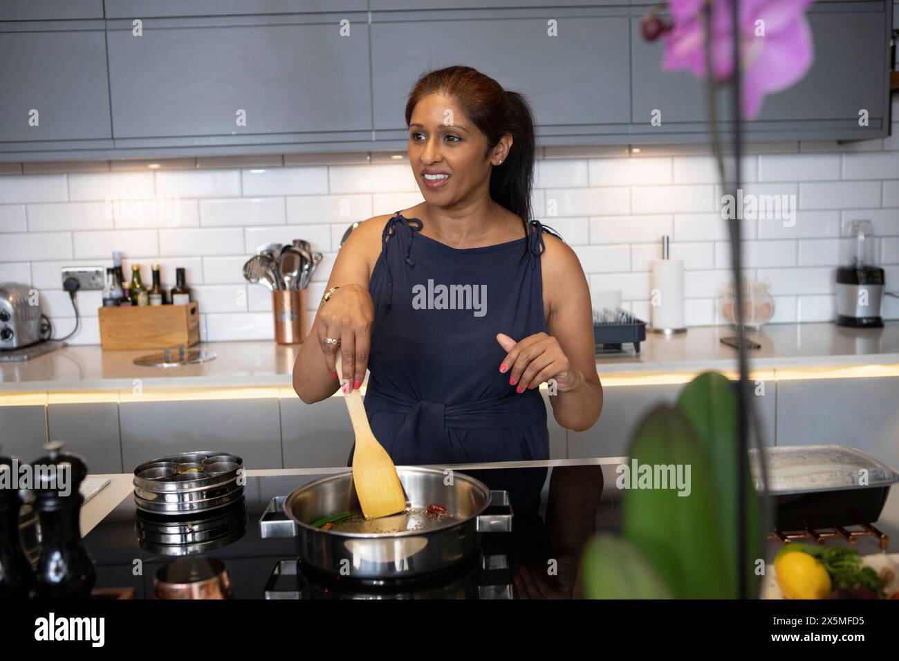 UK, London, Smiling woman cooking in kitchen Stock Photo - Alamy