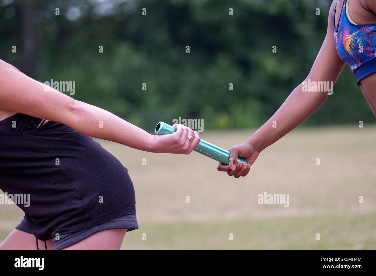 Close-up of runners passing relay baton Stock Photo - Alamy