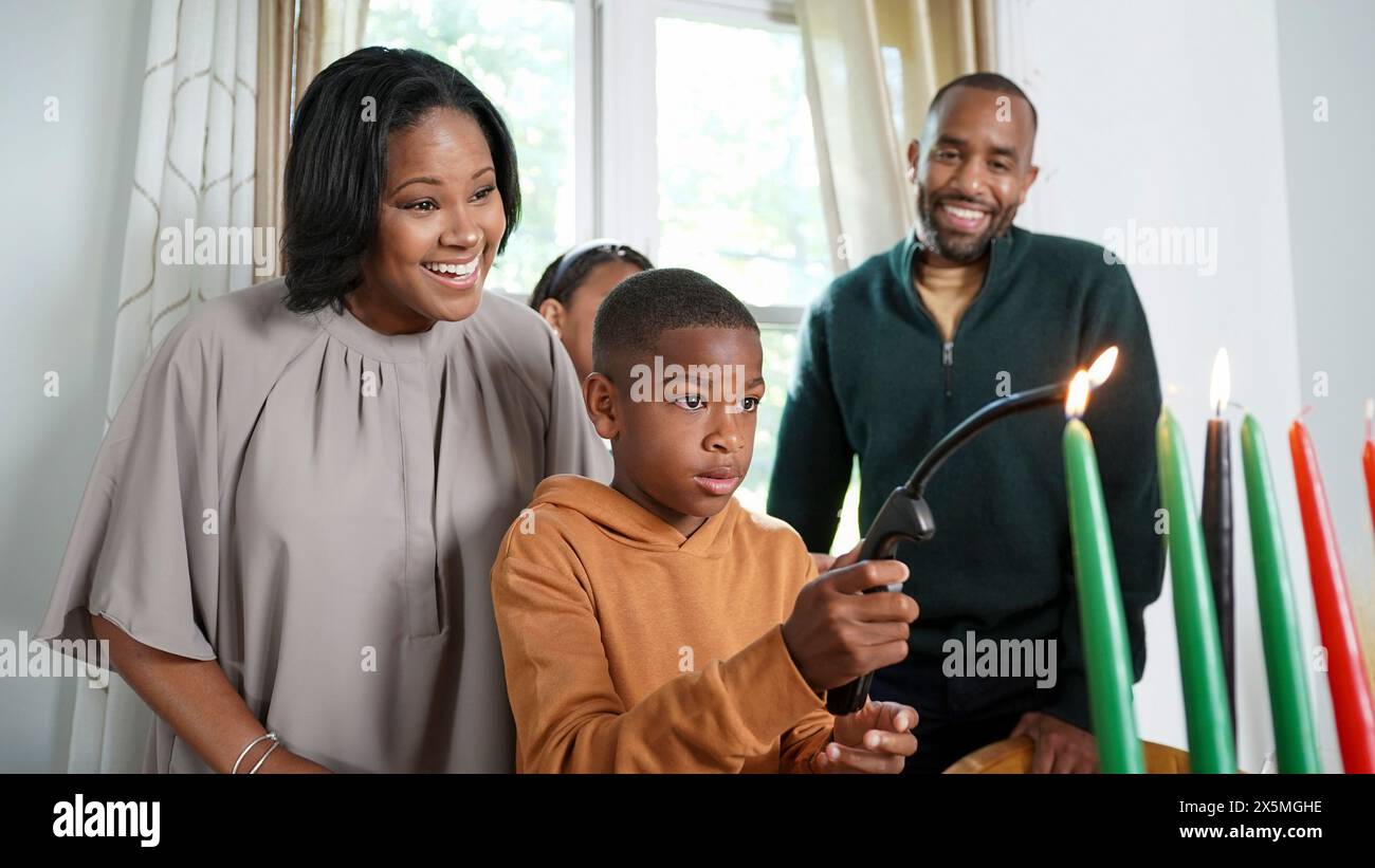 Family with children (8-9, 12-13) lighting kinara candles Stock Photo ...