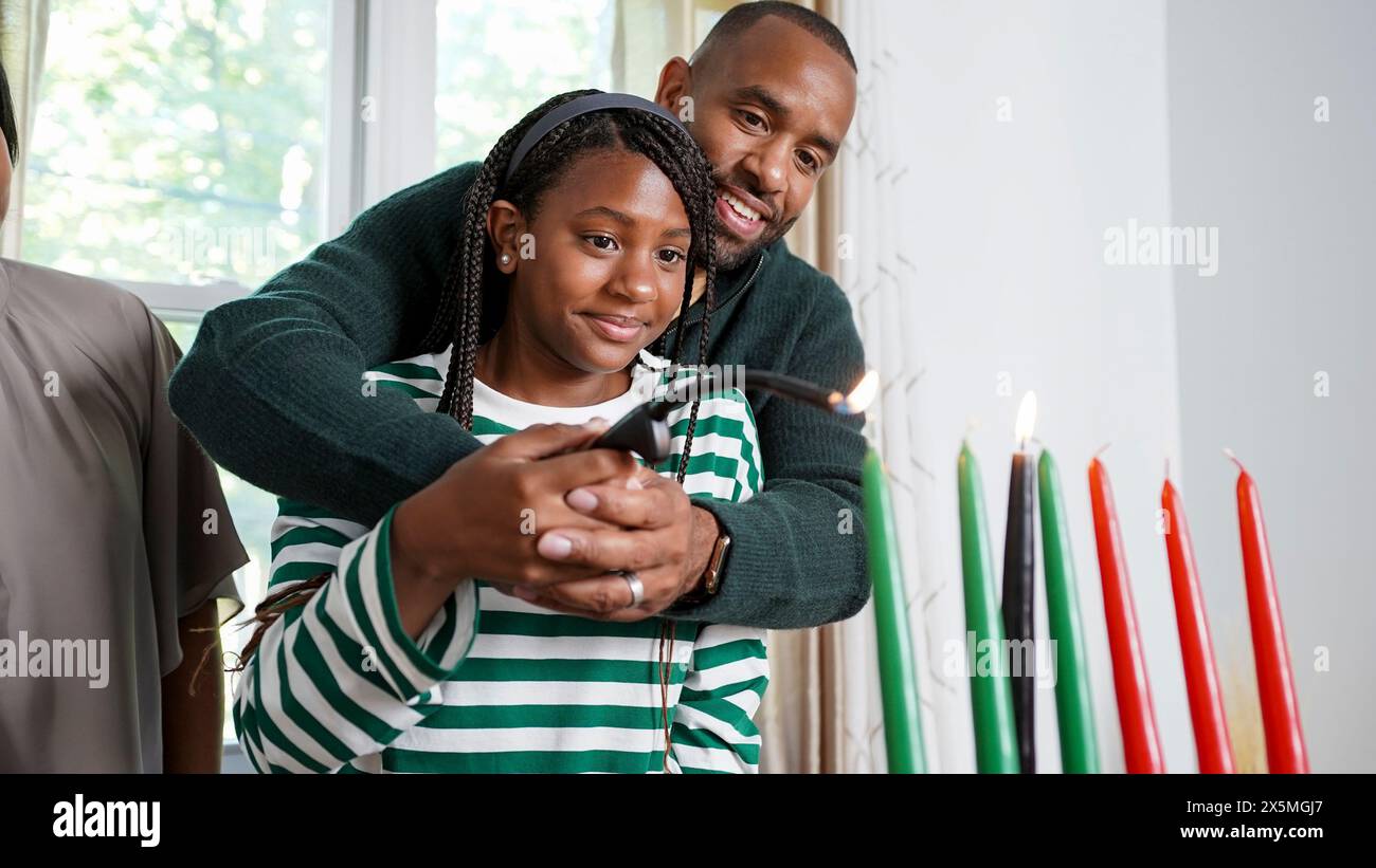 Family with daughter (12-13) lighting kinara candles Stock Photo - Alamy