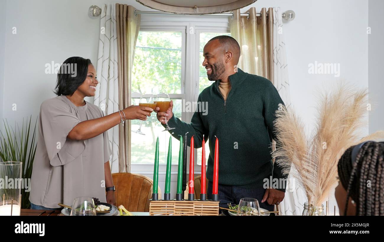Mature couple raising toast during Kwanzaa meal Stock Photo - Alamy