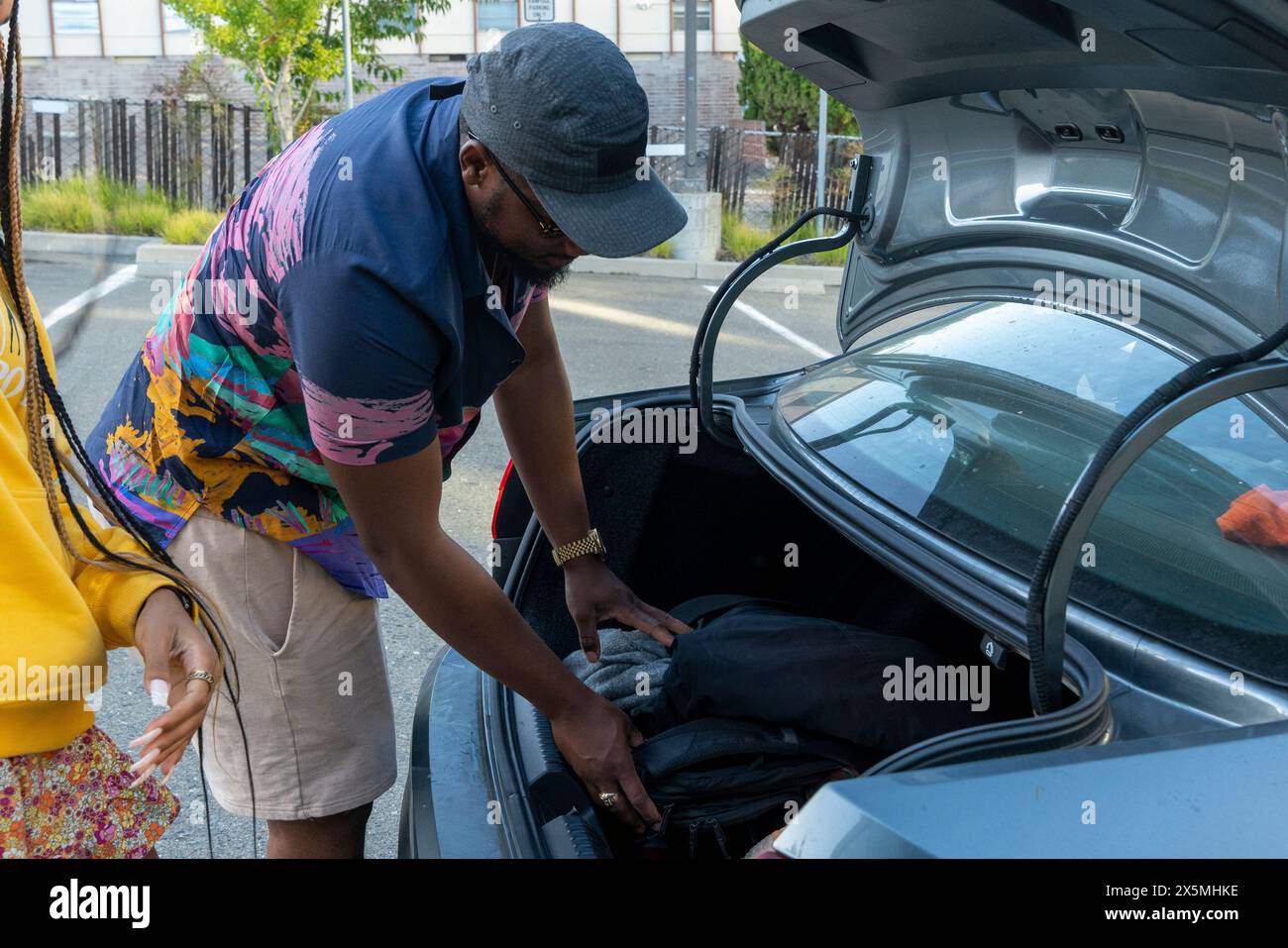 Couple checking luggage in car trunk on road trip Stock Photo - Alamy