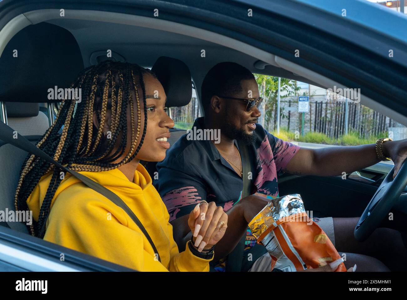 Couple eating snacks in car on road trip Stock Photo - Alamy
