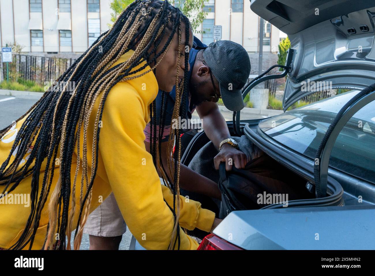Couple checking luggage in car trunk on road trip Stock Photo - Alamy
